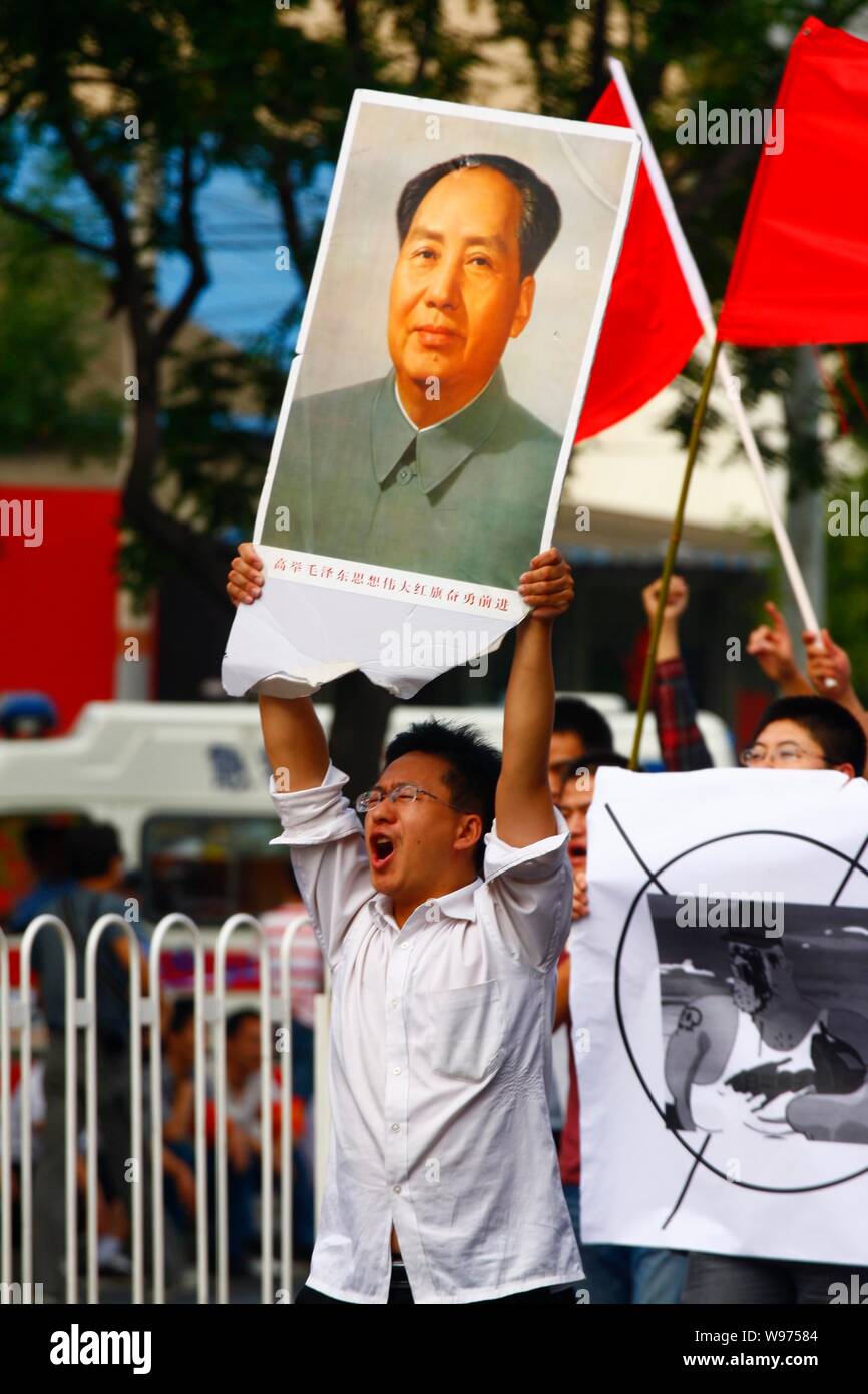 A Chinese protestor holds up a picture of Chairman Mao Zedong during an ...