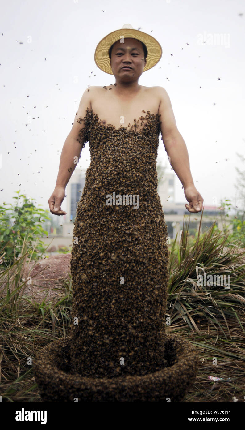 Chinese beekeeper She Ping whose body is covered by bees poses during a ...