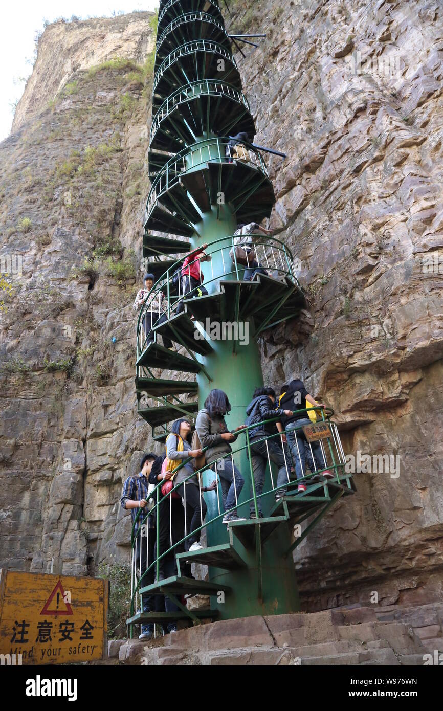 Tourists walk upstairs on a spiral staircase as they visit Taihang ...