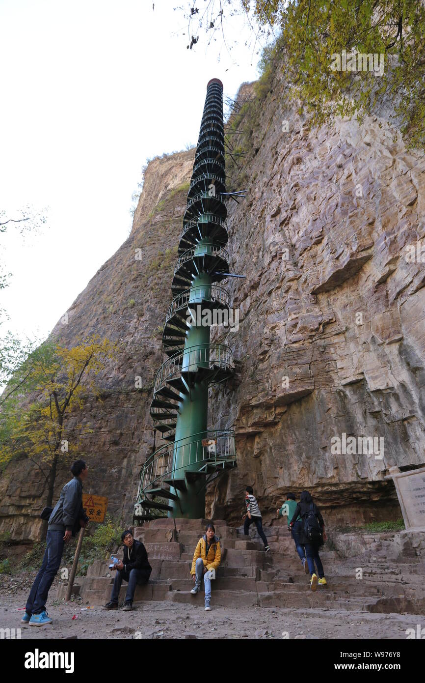Tourists walk upstairs on a spiral staircase as they visit Taihang ...