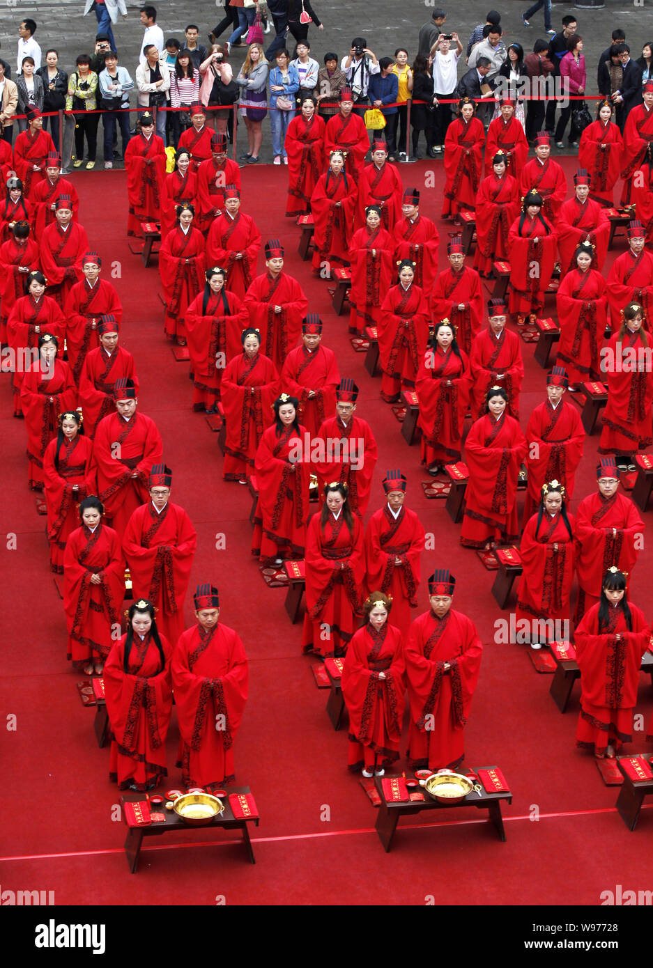Couples of newlyweds dressed in traditional Han costumes pose during a ...