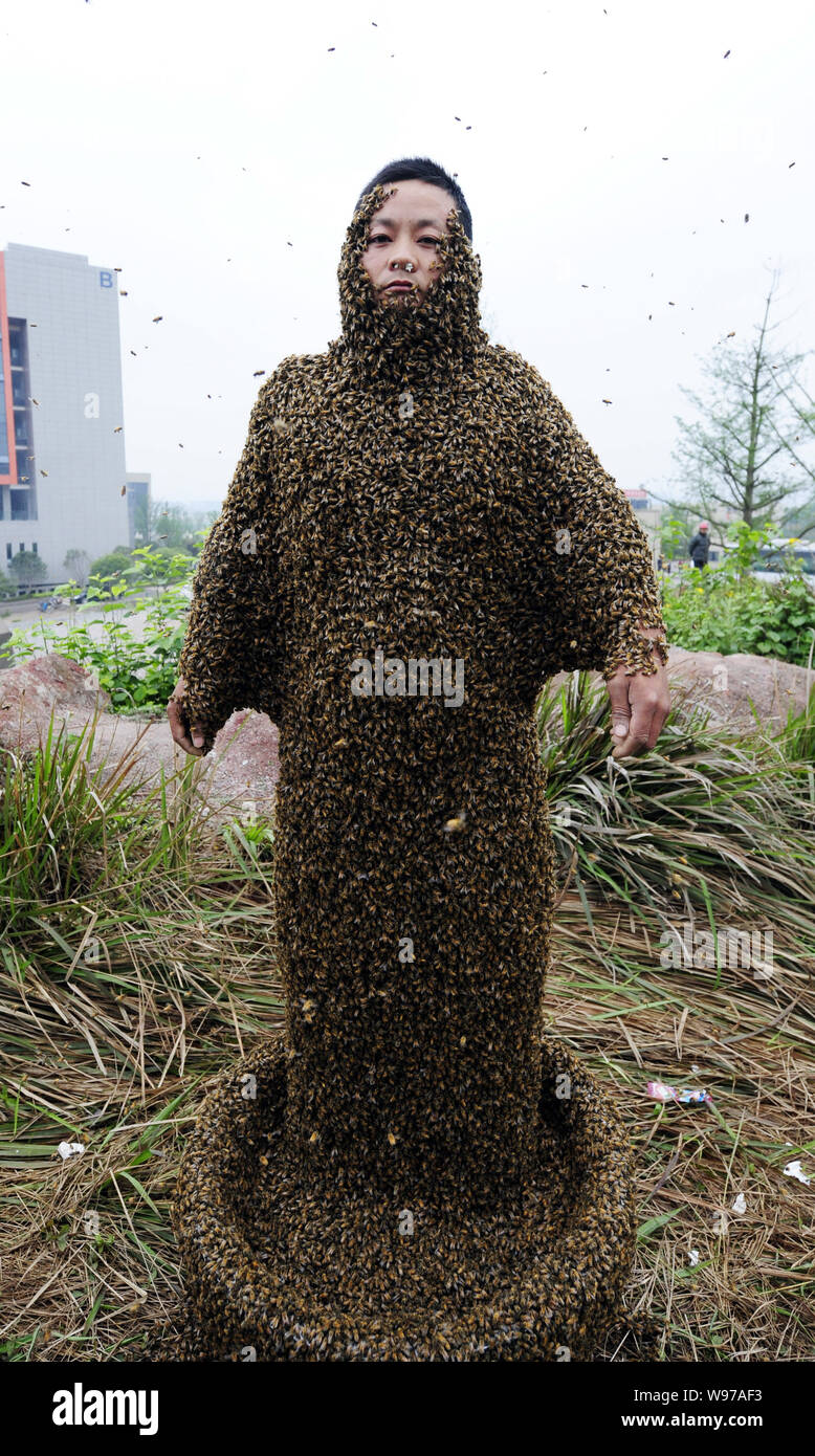 Chinese beekeeper She Ping whose body is covered by bees poses during a ...