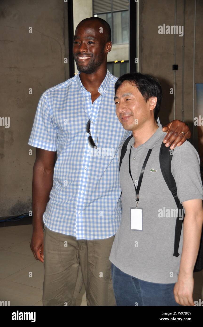NBA star Emeka Okafor of the New Orleans Hornets poses with a fan after ...