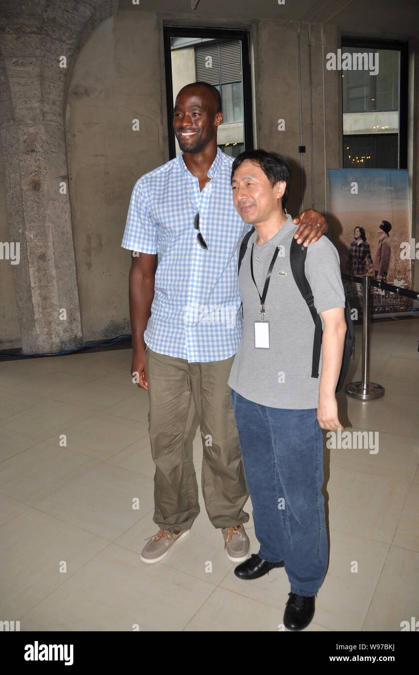 NBA star Emeka Okafor of the New Orleans Hornets poses with a fan after ...