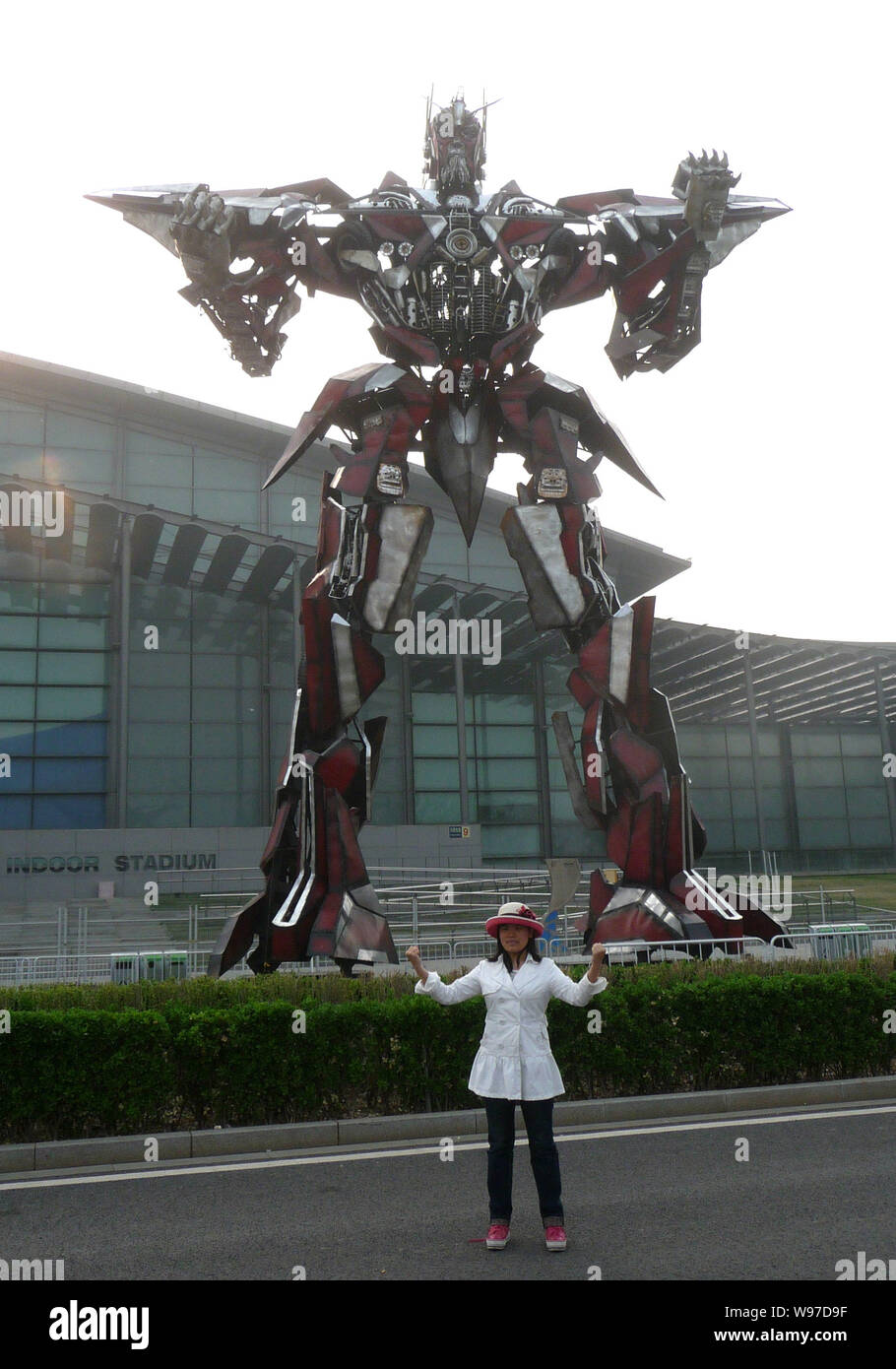 A woman poses by a giant transformer model at Beijing Olympic Park in ...