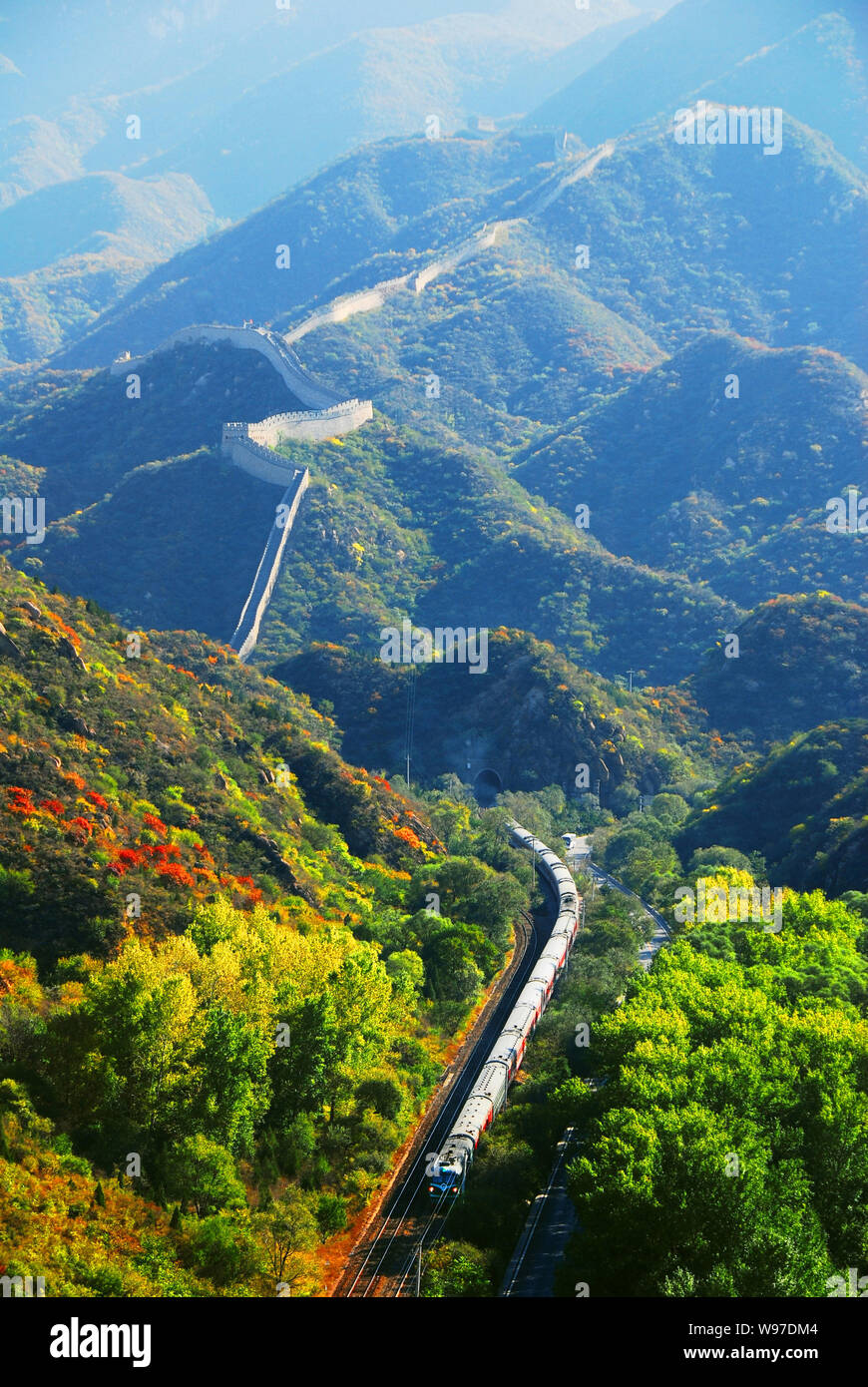 A passenger train passes through a tunnel under the Badaling Great Wall ...