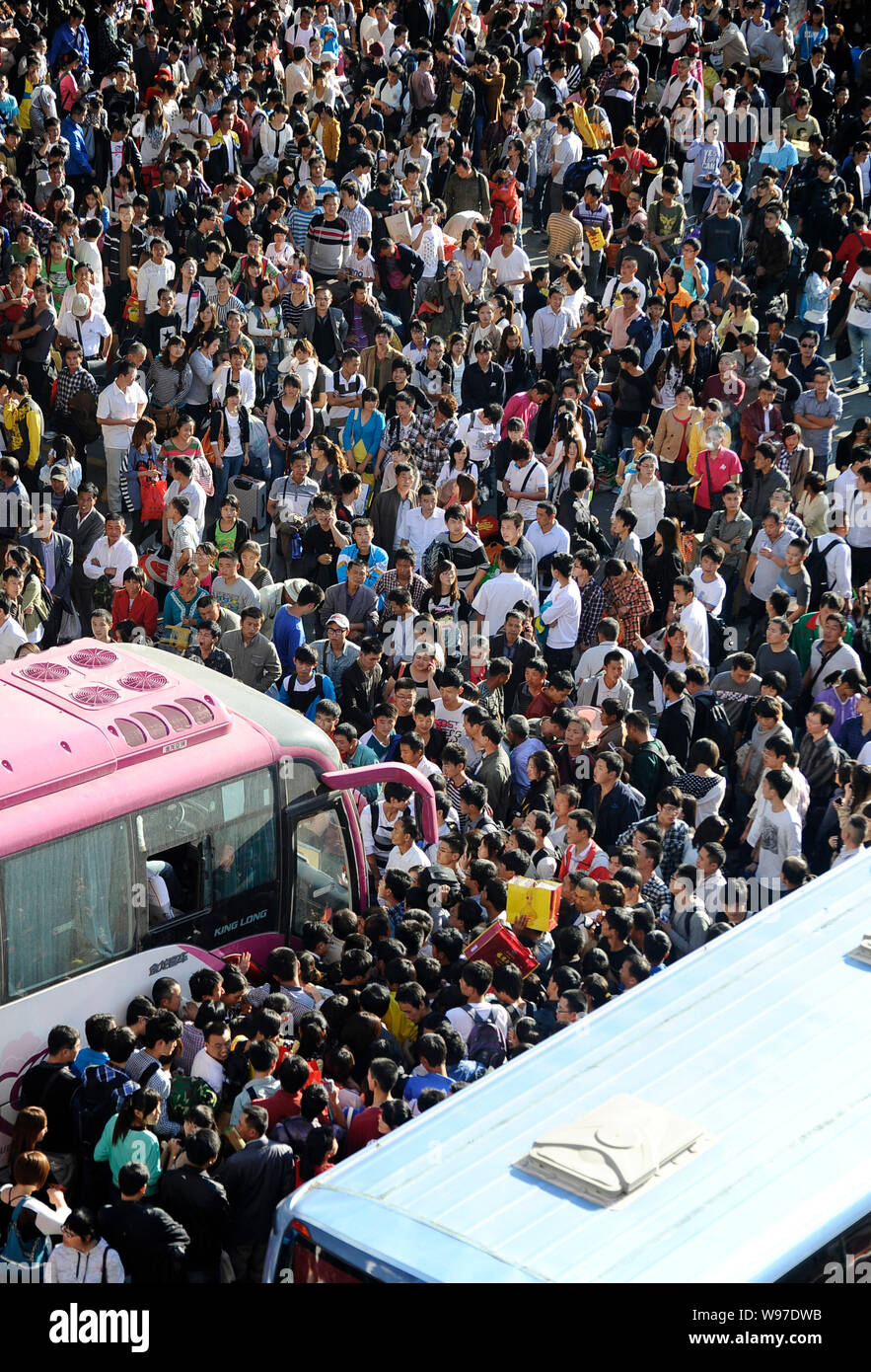 Chinese travelers crowd around buses at a long-distance bus station ...