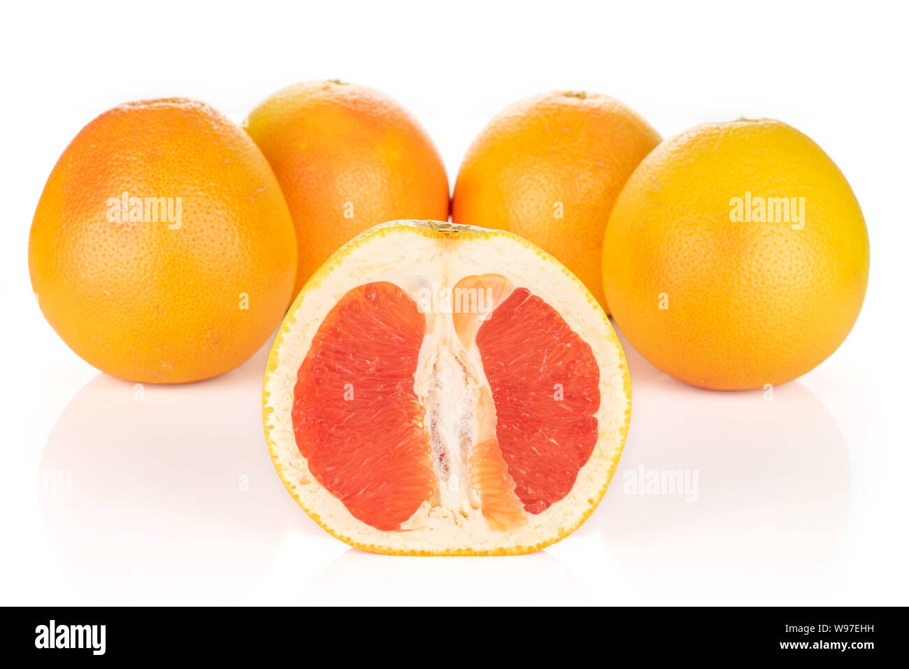 Group of four whole one half of fresh pink grapefruit arranged ...