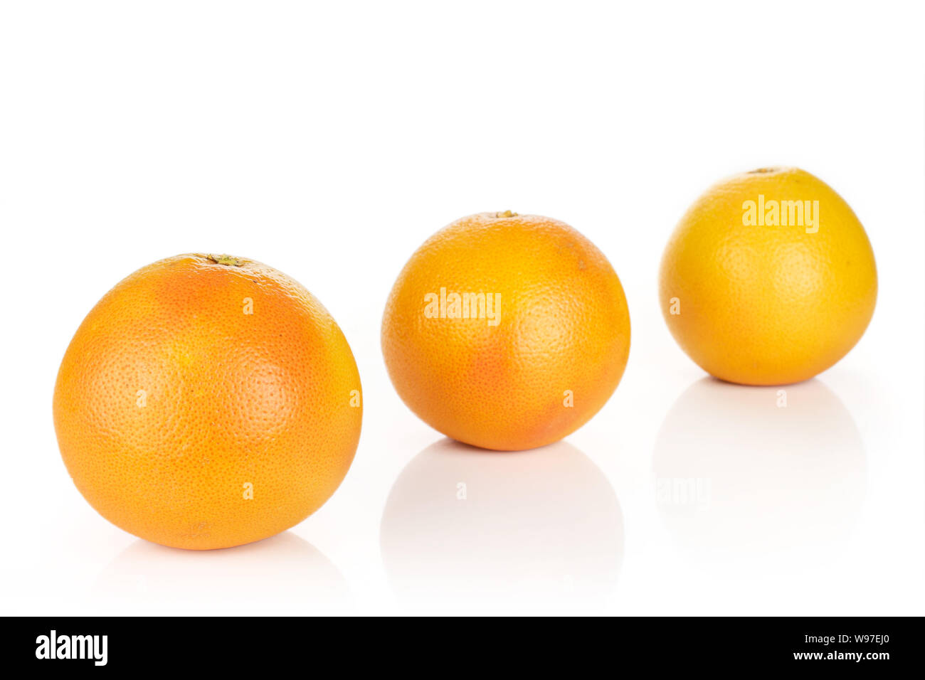 Group of three whole fresh pink grapefruit placed diagonally in line ...
