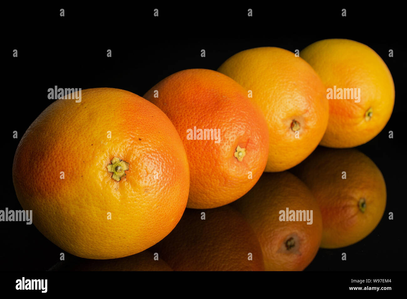 Group of four whole fresh pink grapefruit placed diagonally in line ...