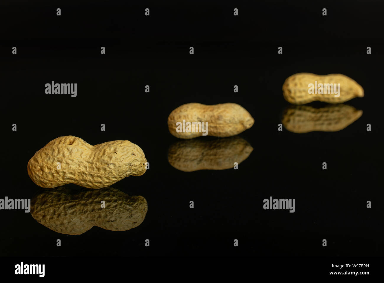 Group of three whole natural yellow peanut placed diagonally in line ...