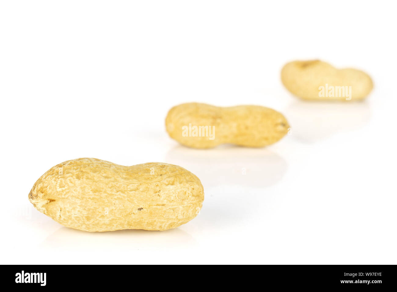 Group of three whole natural yellow peanut placed diagonally in line ...