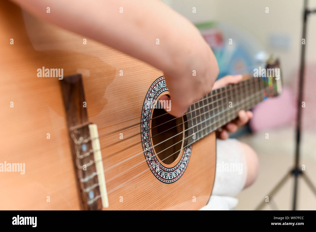 Girl learns to play guitar during a music lesson on the instrument ...