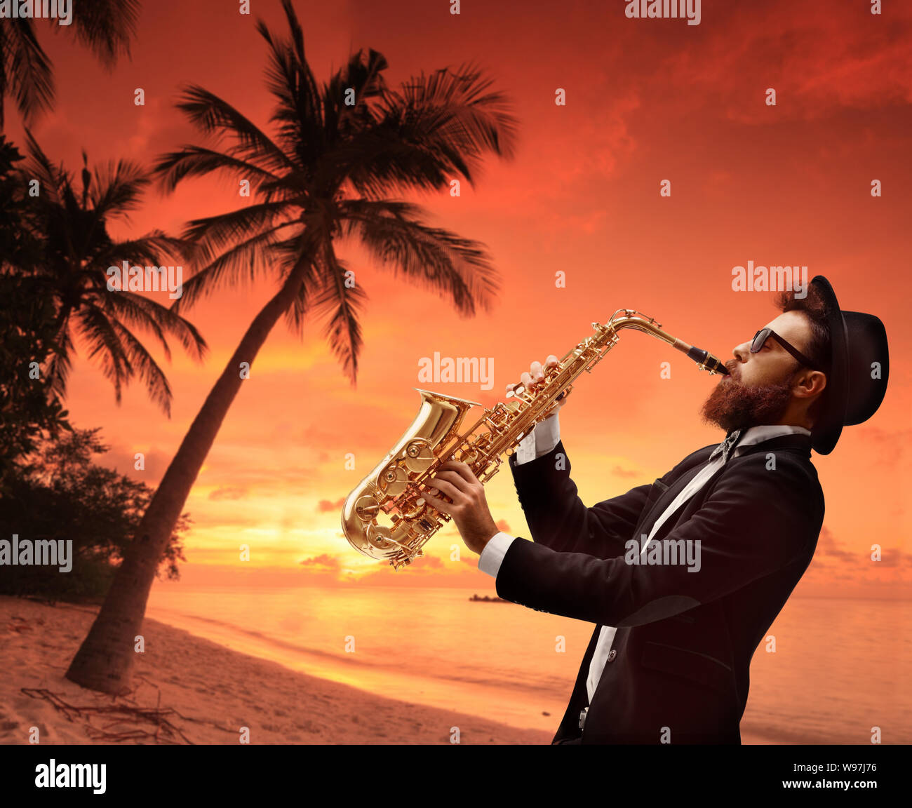 Male artist playing saxophone with a beach and a palm on sunset as a ...