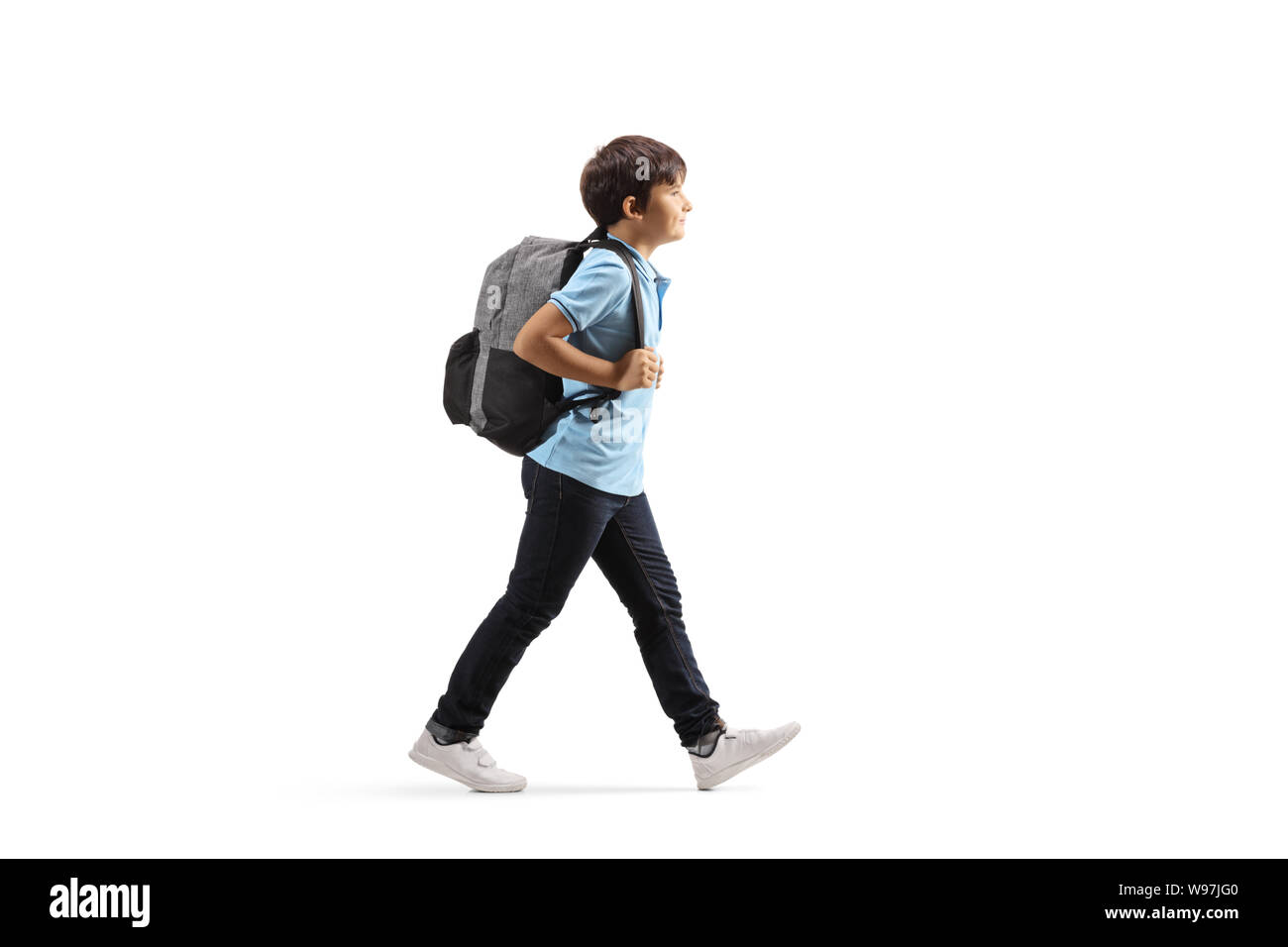 Full length profile shot of a schoolboy with a backpack walking ...