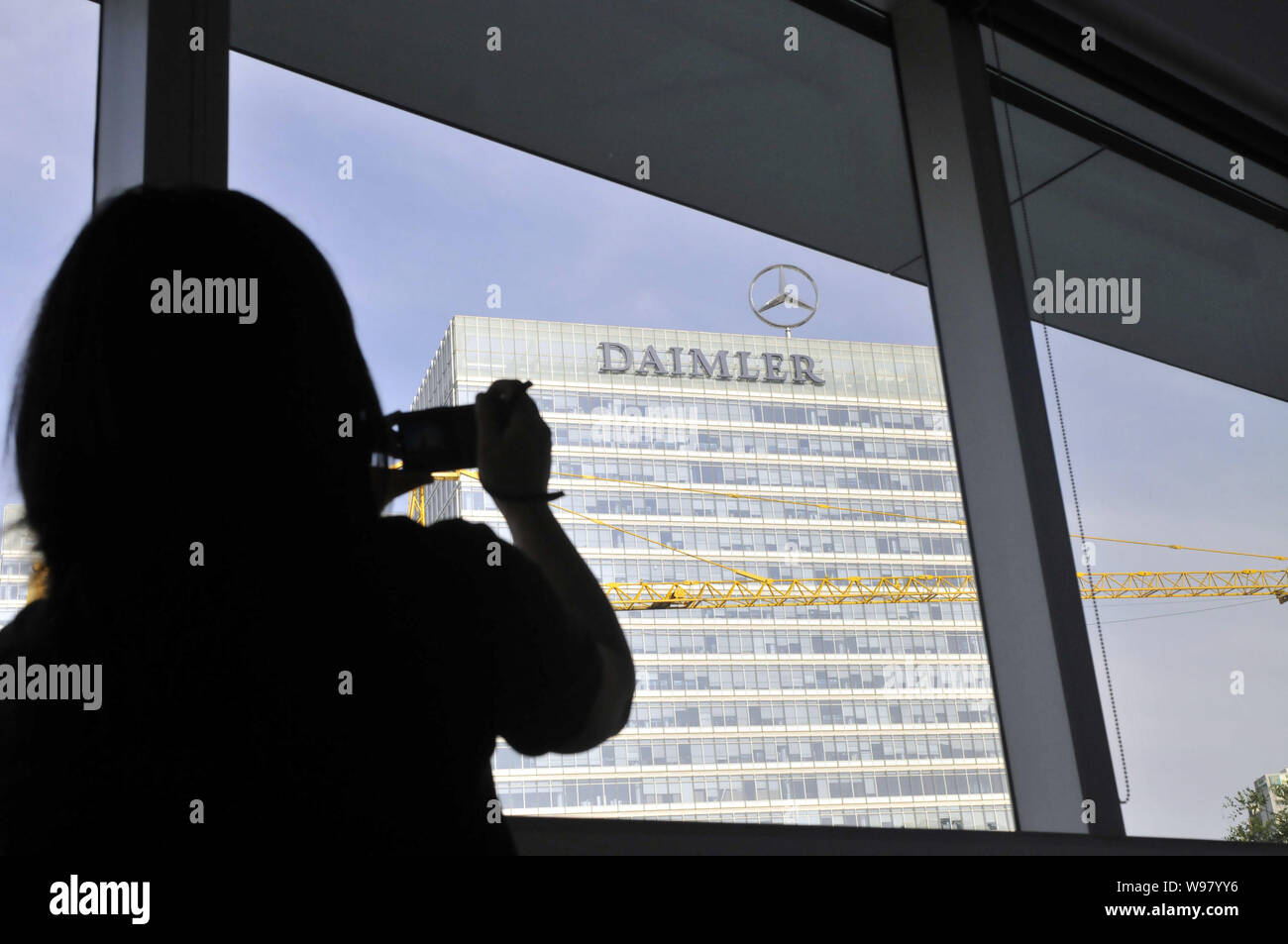A woman takes photos of the Daimler Tower where Mercedes-Benz (China ...