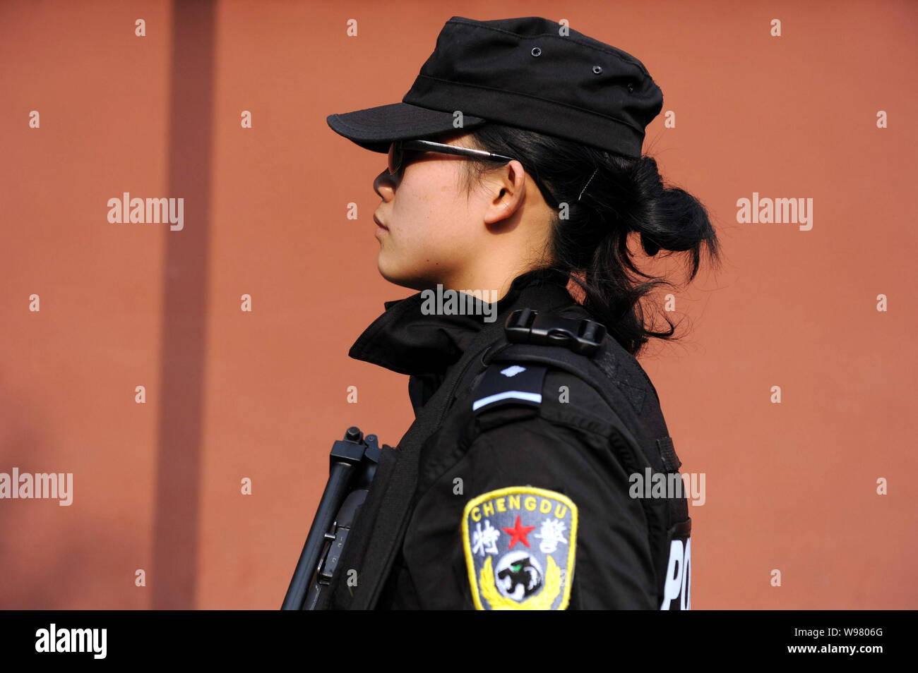 A Chinese special policewoman patrols a street in Chengdu city ...