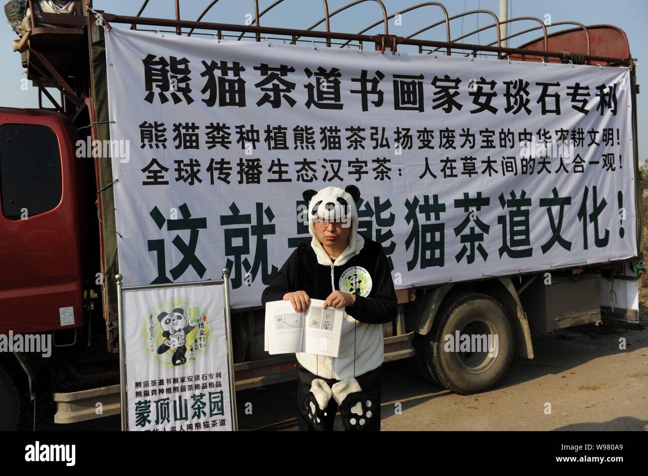 An Yanshi wearing a set of panda is pictured by a truck with a ...