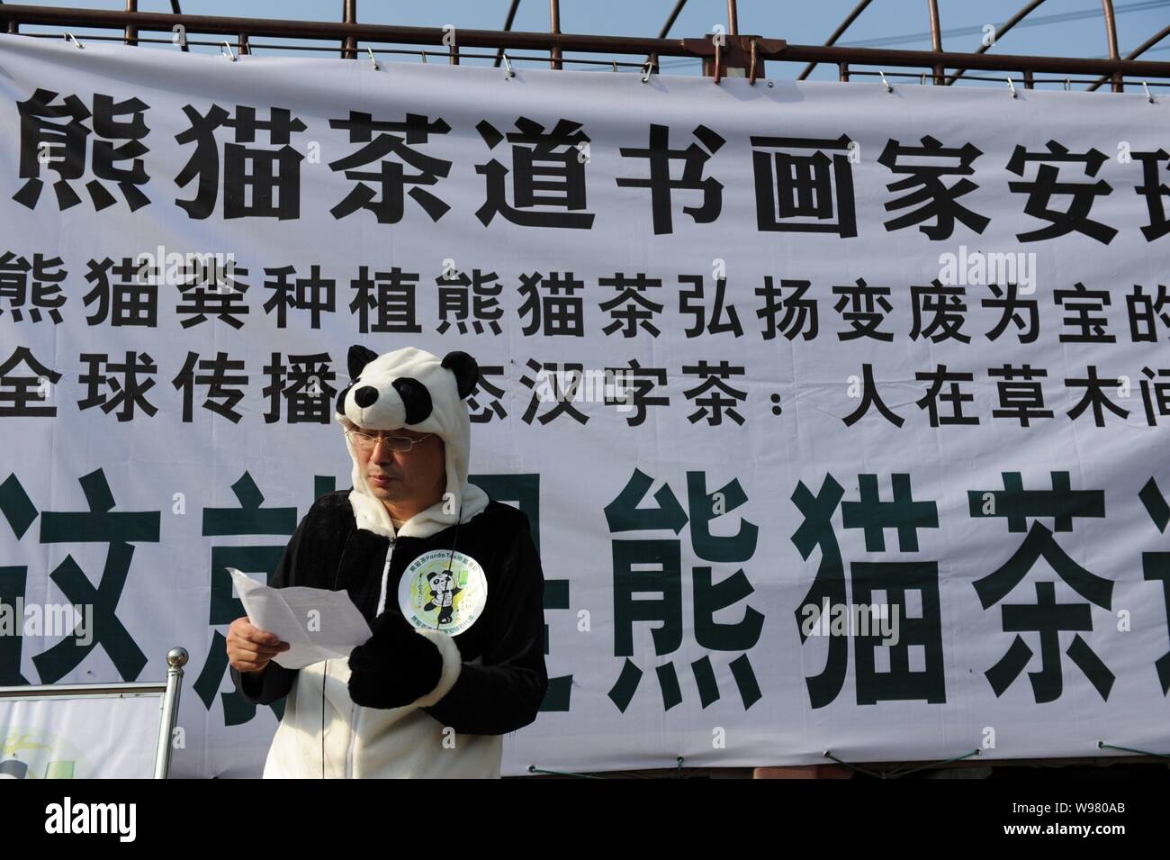 An Yanshi wearing a set of panda is pictured by a truck with a ...
