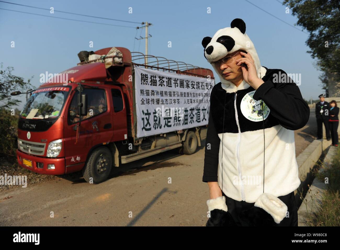 An Yanshi wearing a set of panda is pictured by a truck with a ...