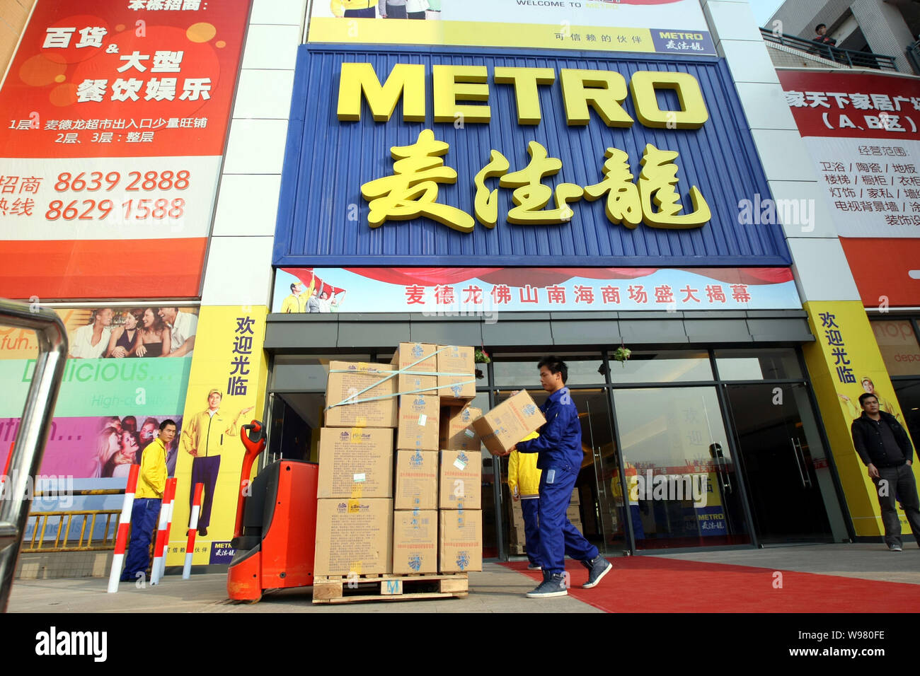 A Chinese worker delivers goods at the first Metro store in Foshan city ...