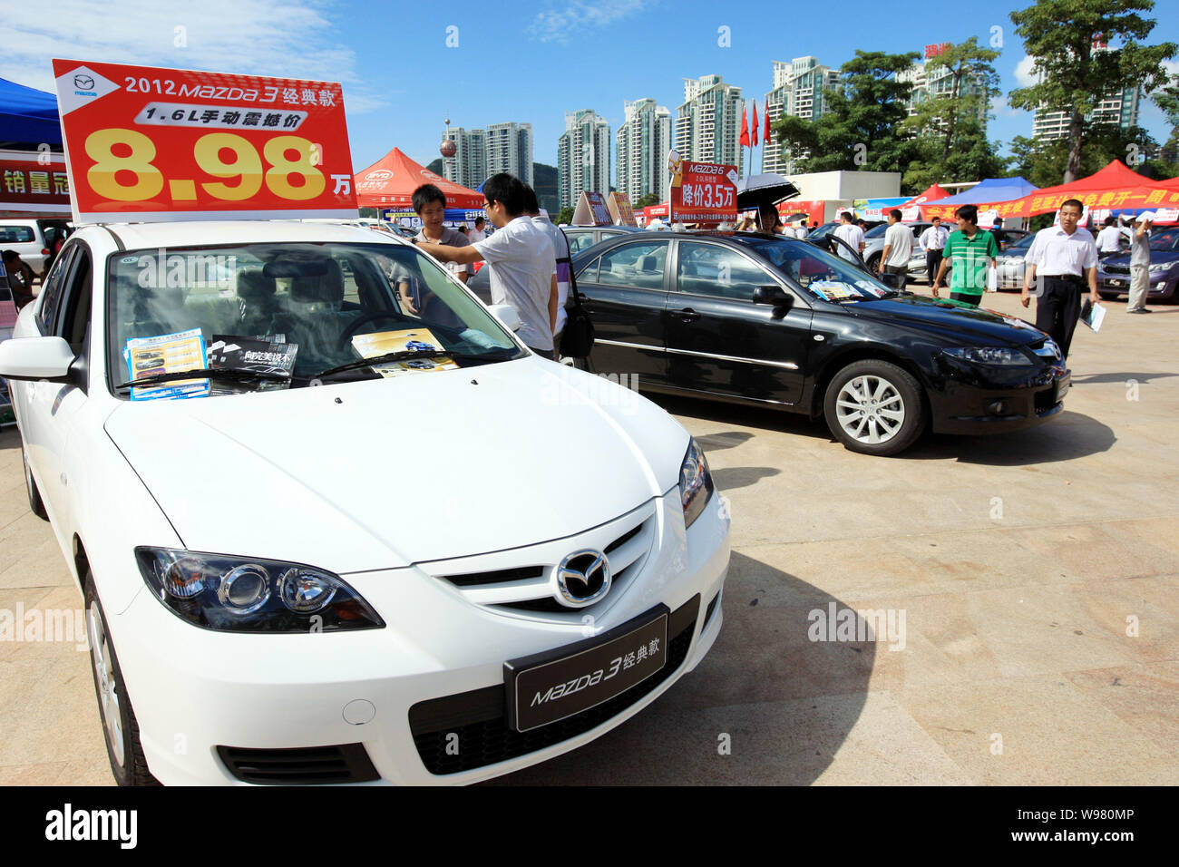 --FILE--Visitors look at Mazda cars during an auto show in Sanya city ...