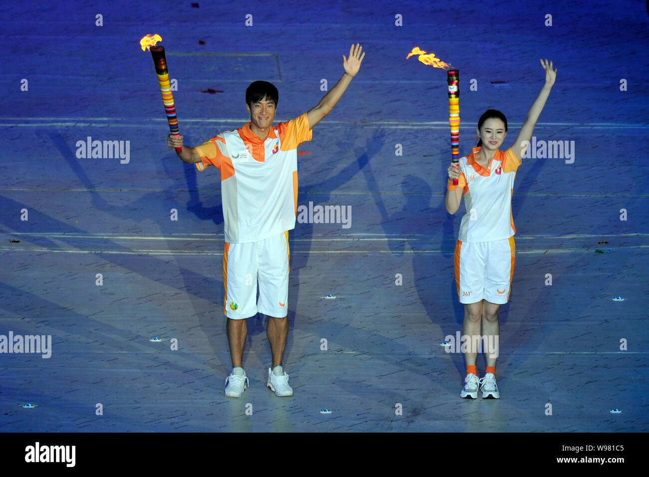 Chinese hurdler Liu Xiang and gymnast Dai Feifei of China hold torches ...