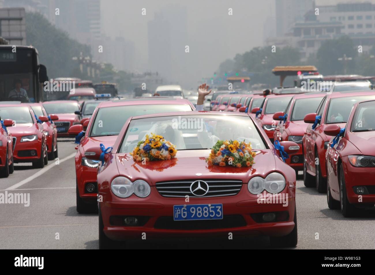 A flashy fleet of 35 red cars parade down Changan Avenue in Beijing ...