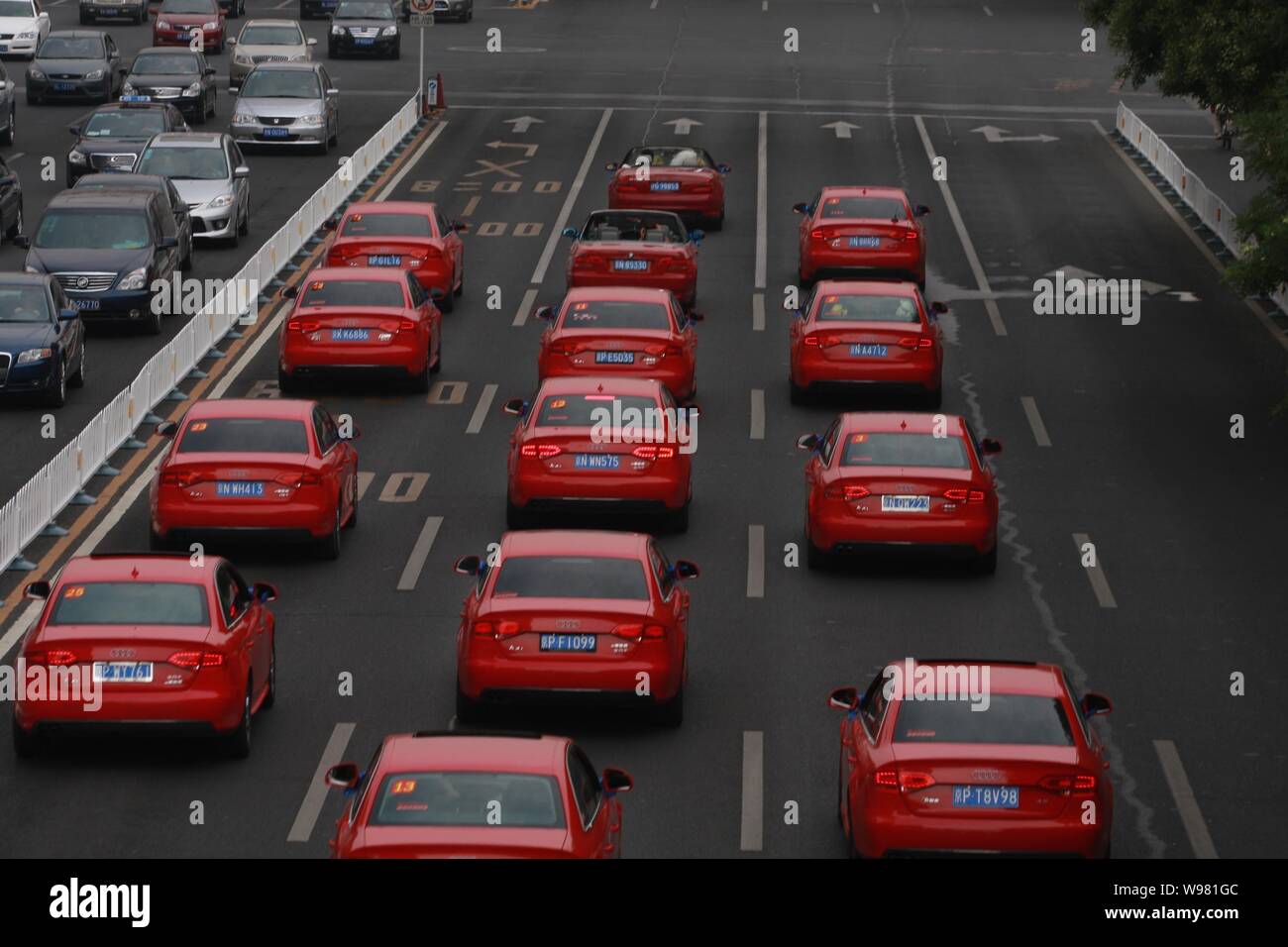 A flashy fleet of 35 red cars parade down Changan Avenue in Beijing ...