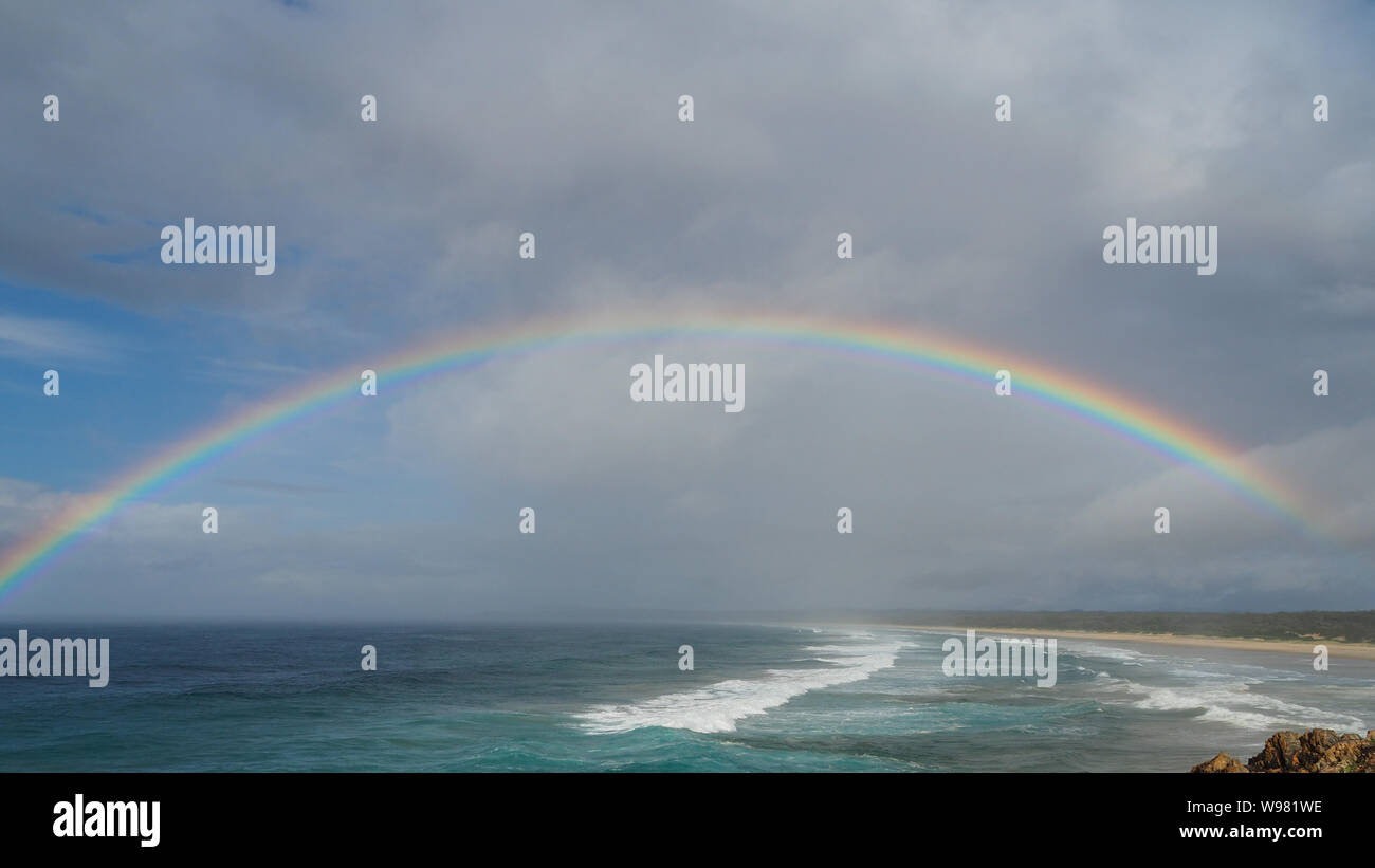Nature, what a stunner! A beautiful Rainbow arch at the beach, waves ...