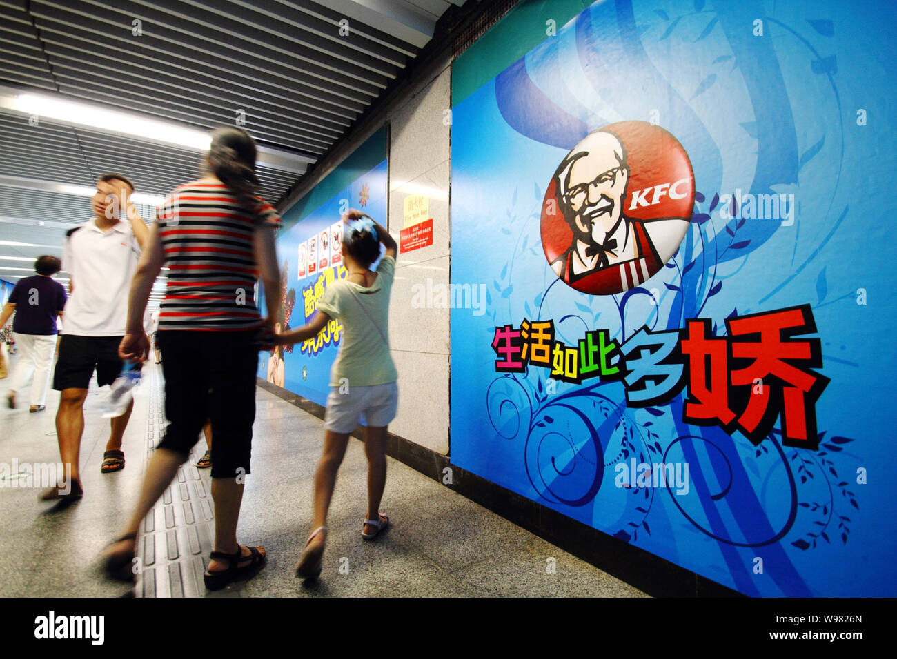 --FILE--Local Chinese residents walk past advertisement for KFC at a ...
