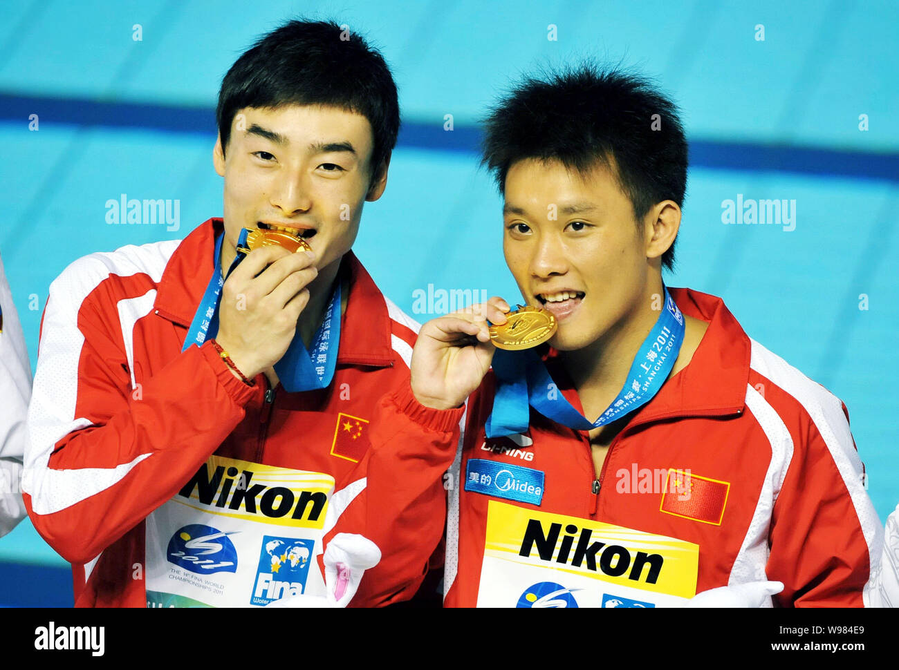 Gold medalists Luo Yutong, right, and Qin Kai of China bite their ...