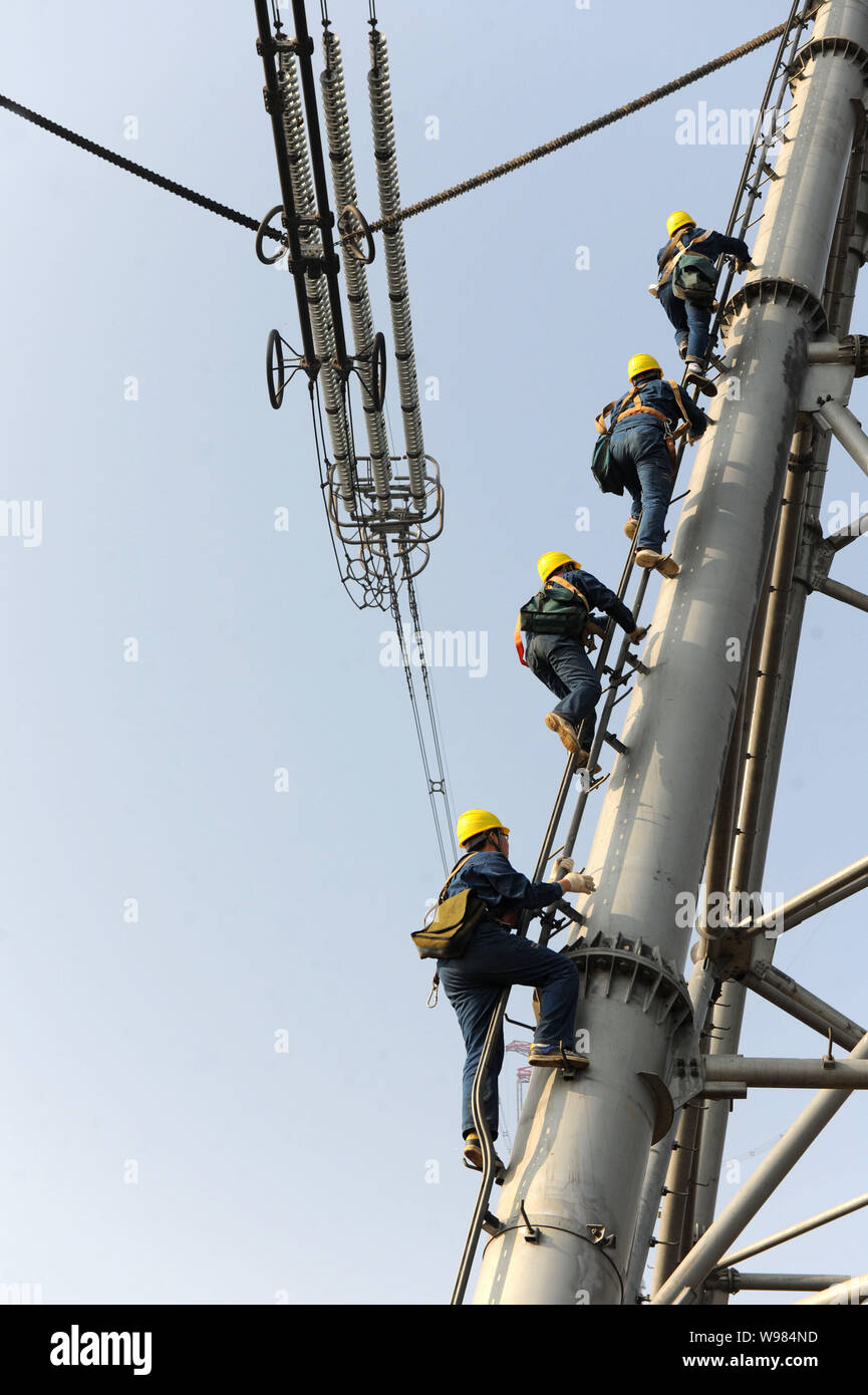 Chinese electricians climp up a pylon to check and repair UHV (ultra ...