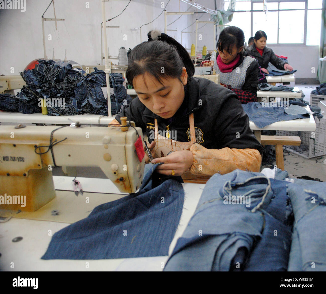 Female factory workers make clothes at a plant in Jian city, east ...