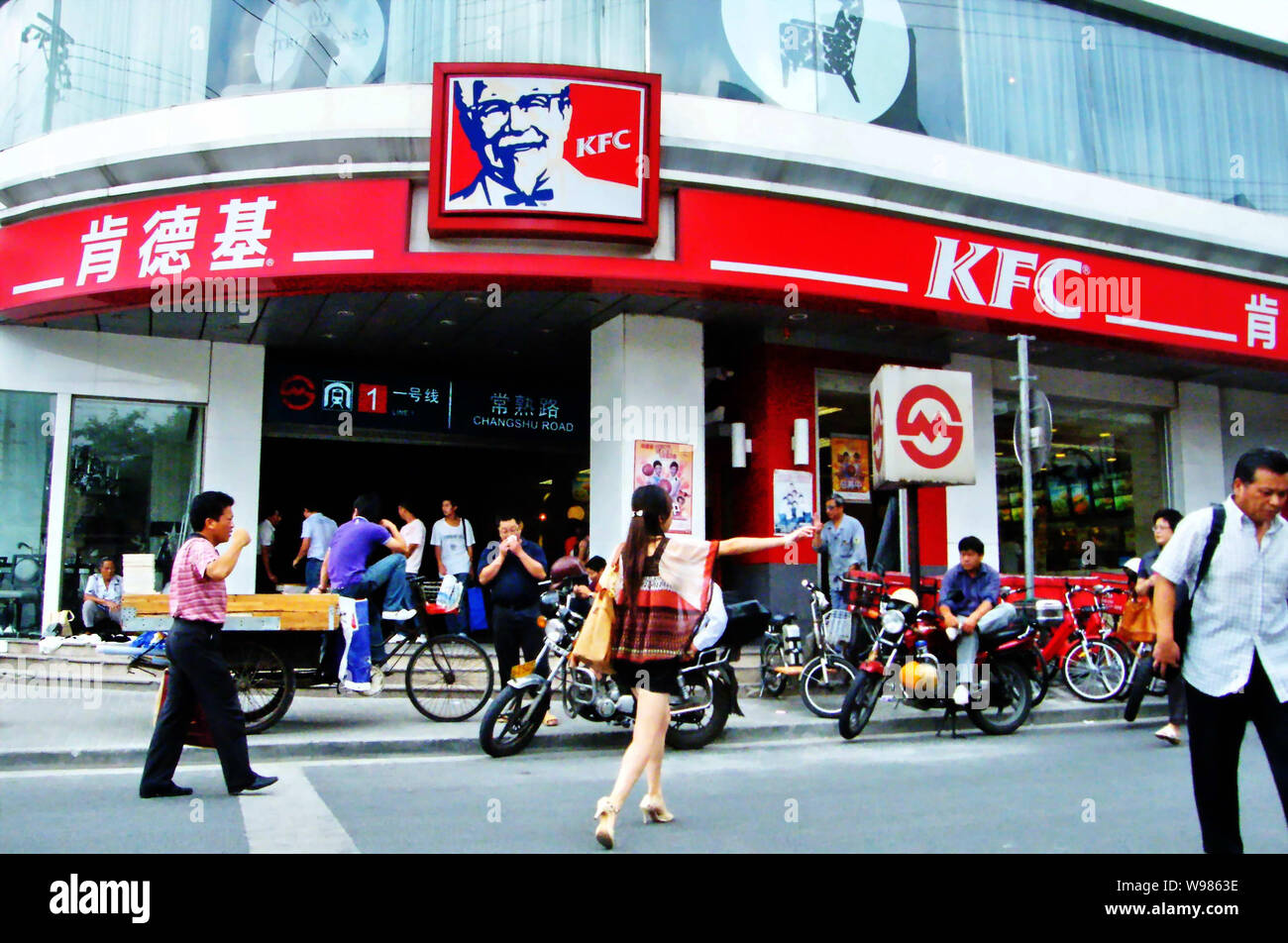 Pedestrians walk past a fast food restaurant KFC in Shanghai, China, 31 ...