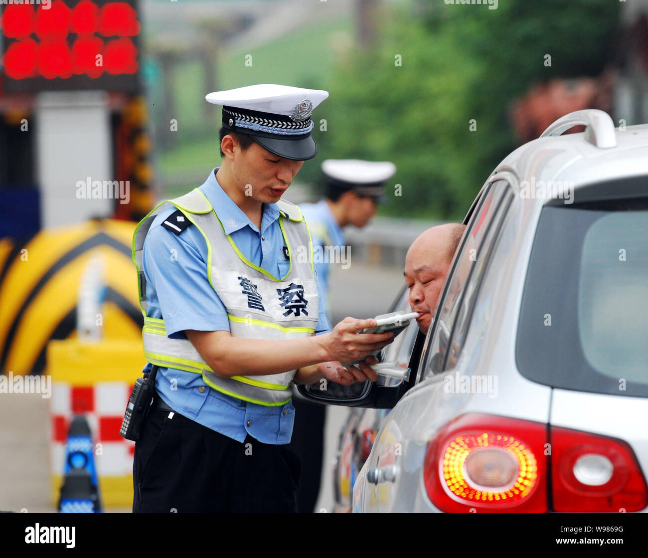 A Chinese police officer uses a detector to measure the alcohol level ...
