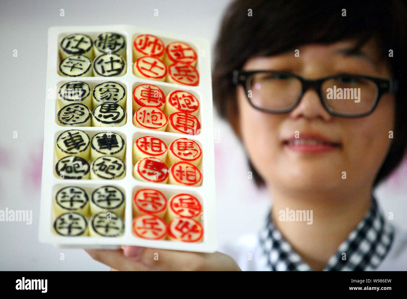 A Chinese worker shows chess pieces made from mooncakes at a bakery in ...