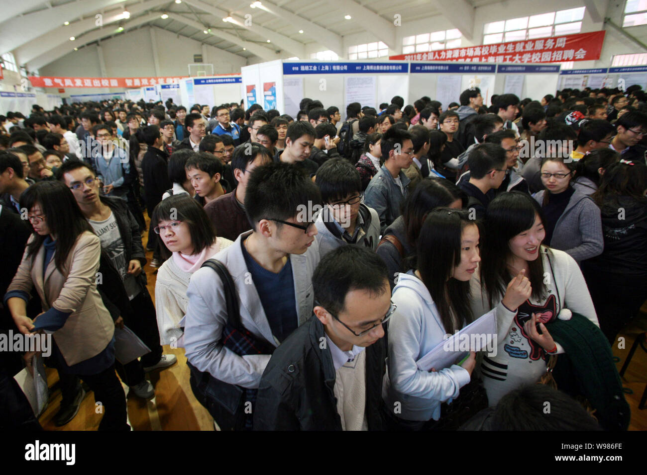 Chinese graduates crowd booths at a job fair during the Shanghai ...