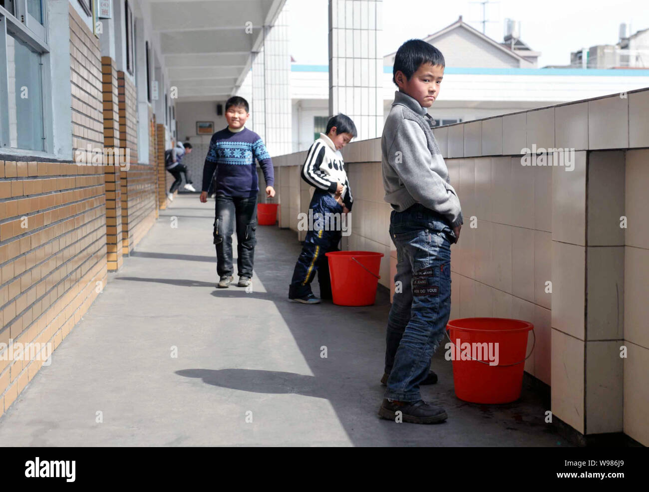 Young Chinese boys pee into plastic barrels at a school in Dongxiang ...
