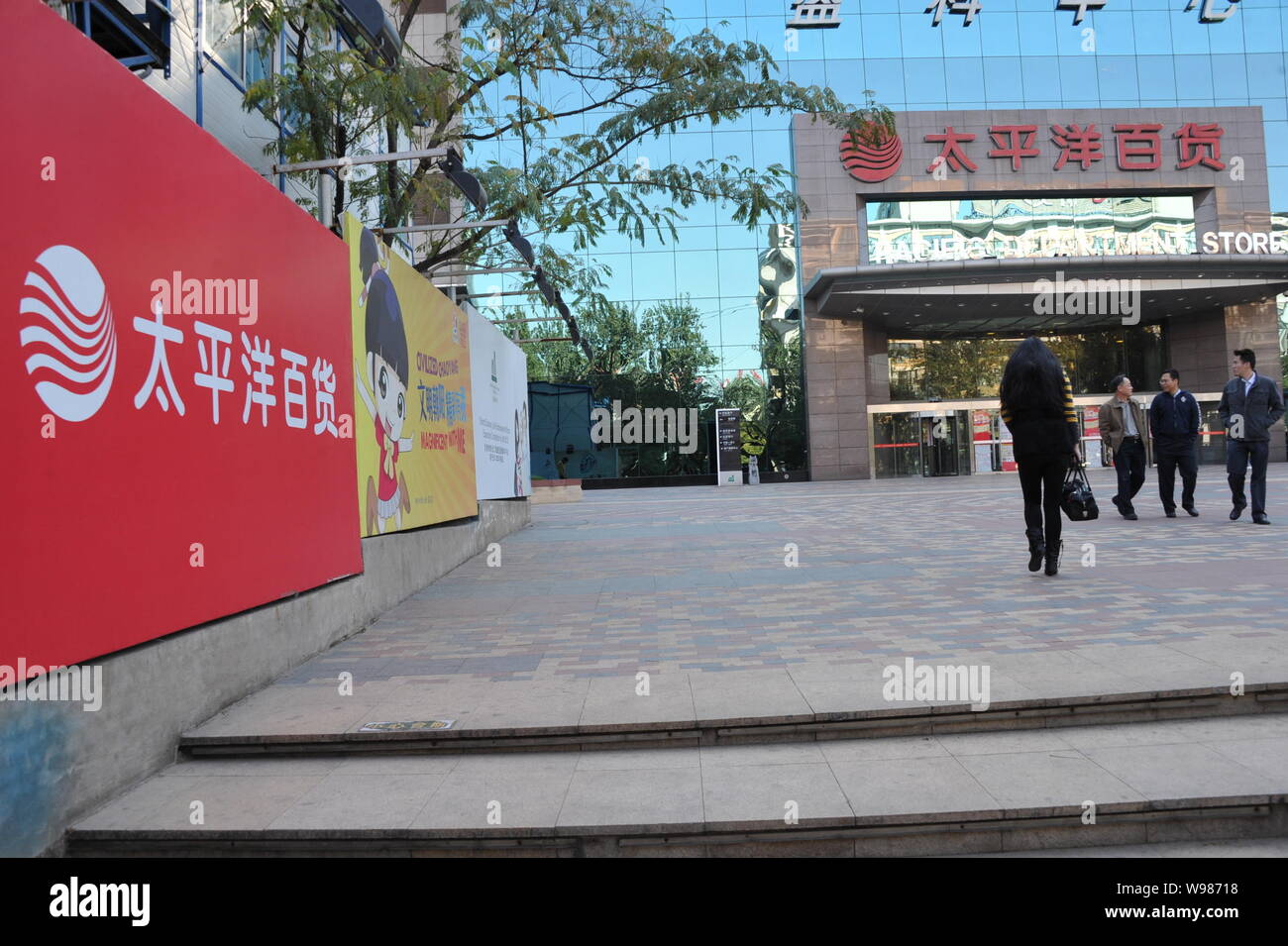 Pedestrians walk past a Pacific Department Store in Beijing, China, 25 ...