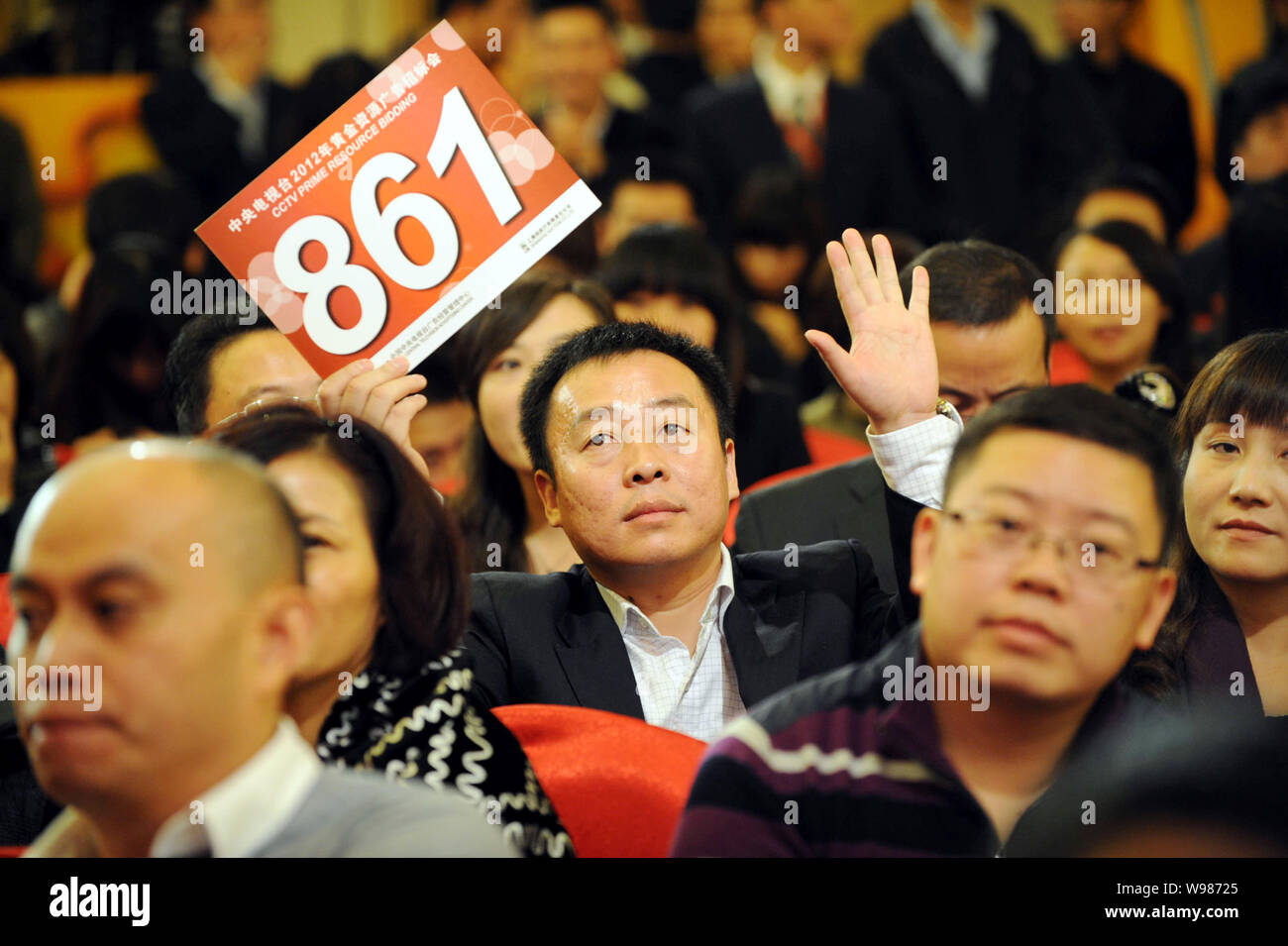 A participant bids during the CCTV 2012 Prime-time Auction in Beijing ...