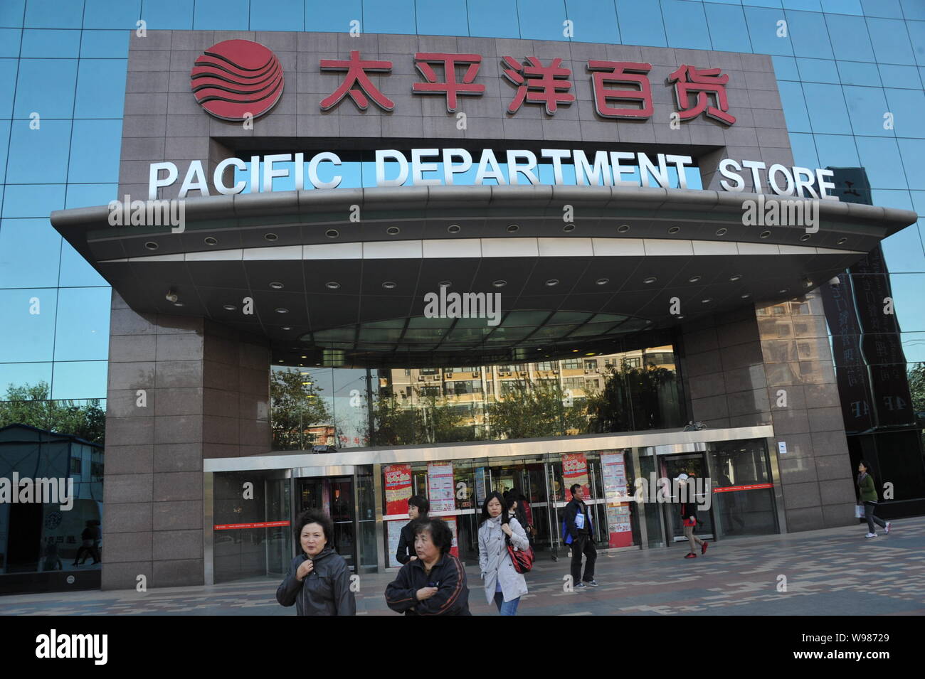 Pedestrians walk past a Pacific Department Store in Beijing, China, 25 ...