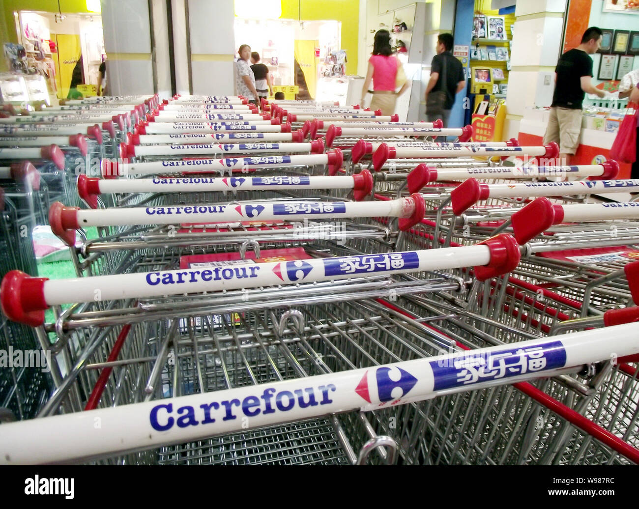 --FILE--Chinese customers walk past rows of shopping carts at a ...