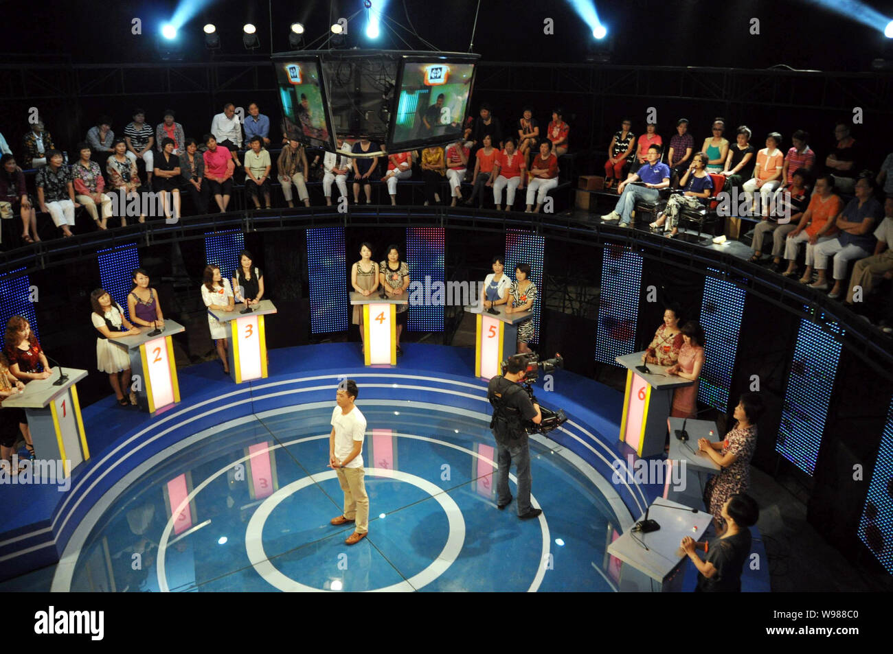A male contestant stands in front of mothers and their daughters during ...