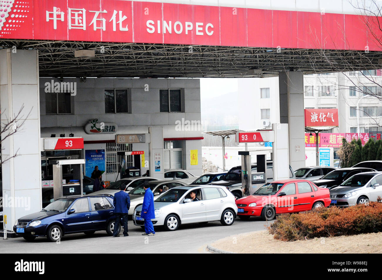 Chinese drivers line up their cars to be refueled at a gas station of ...