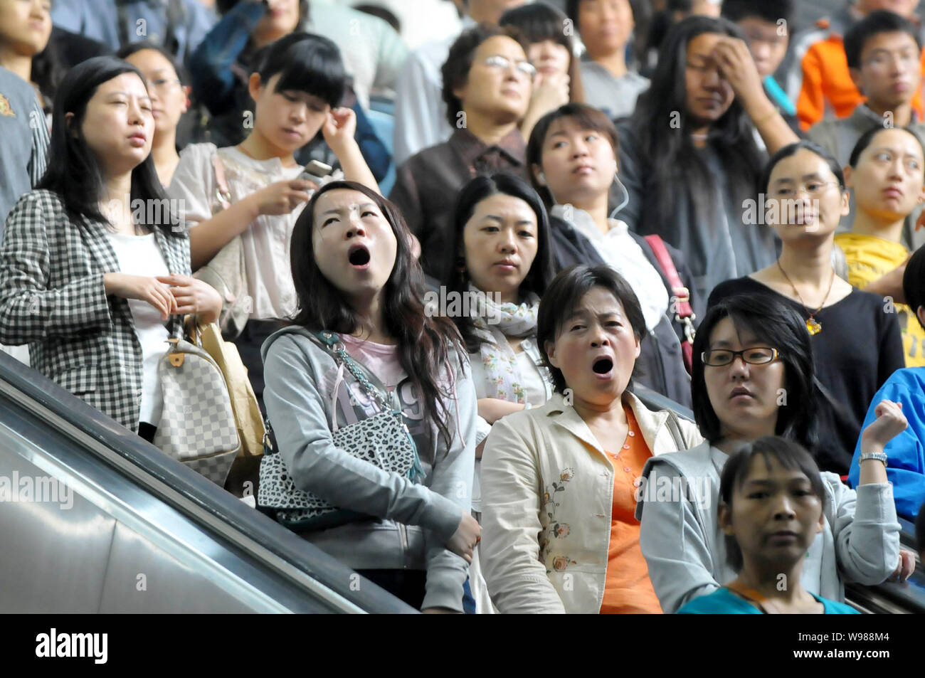 --FILE--Two Chinese woman yawn amongst a crowd of passengers at the ...