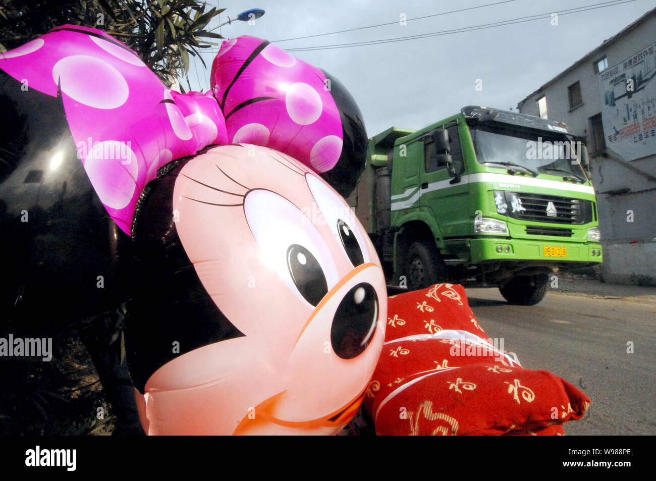 A truck drives past a balloon of the Minnie Mouse near the construction ...