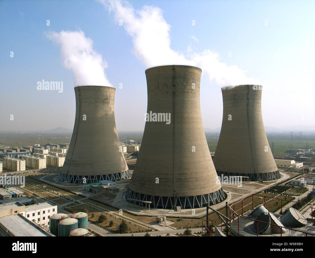 Smoke and steam are emitted from the cooling towers in a coal-fired ...