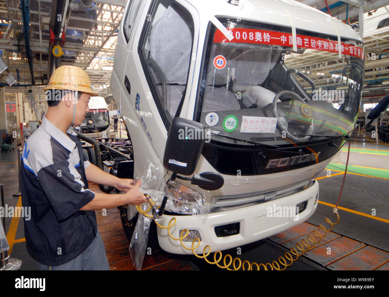 --FILE--A Chinese factory worker assembles a Foton truck on the ...