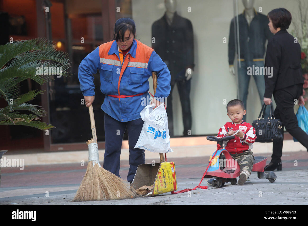 Zeng Yueying takes her son by using a rope connecting her with a toy ...
